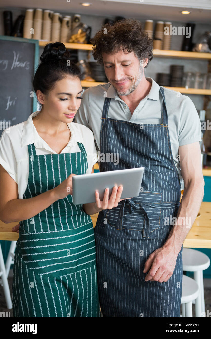 Waiter and waitress discussing over digital tablet Stock Photo - Alamy