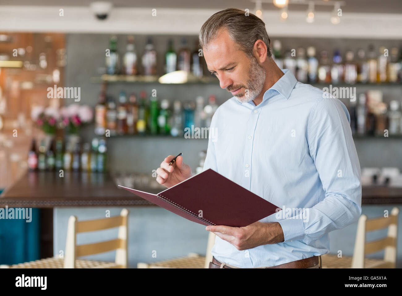 Confident man writing in a file Stock Photo - Alamy