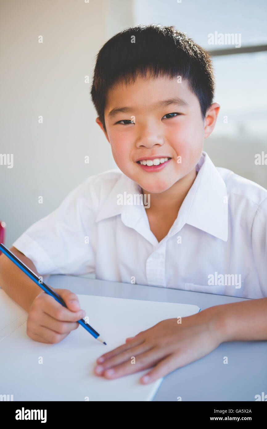 Schoolboy doing homework in classroom Stock Photo - Alamy