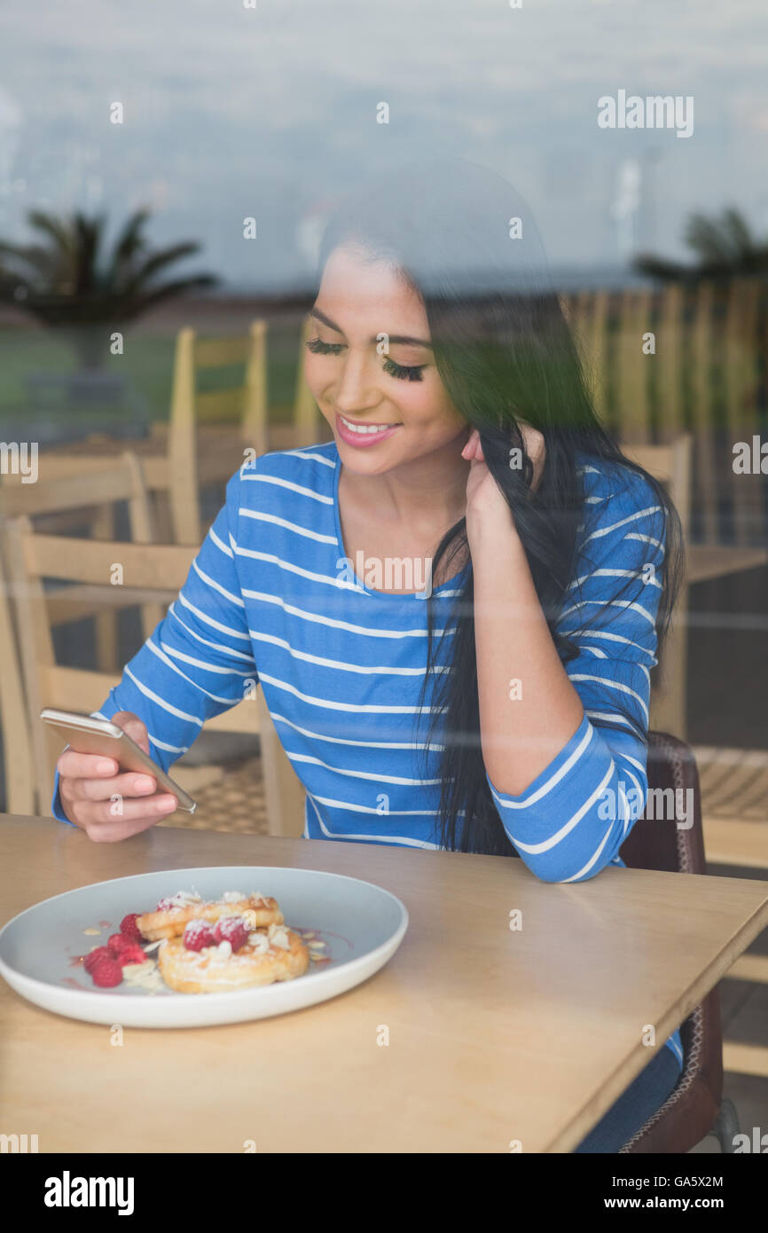 Woman sitting table cell phone hi-res stock photography and images - Alamy