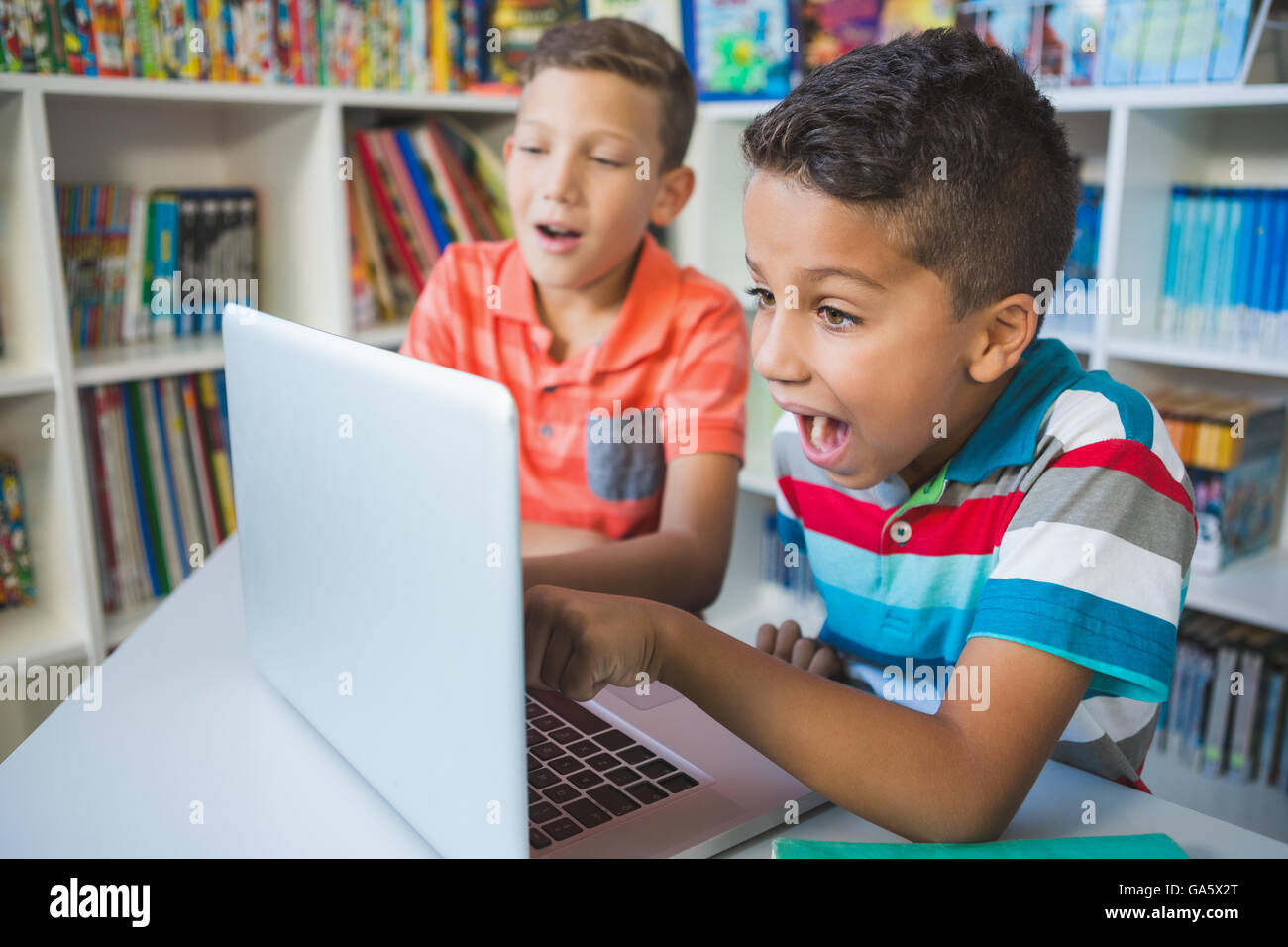 Schoolkids sitting table using computer hi-res stock photography and ...