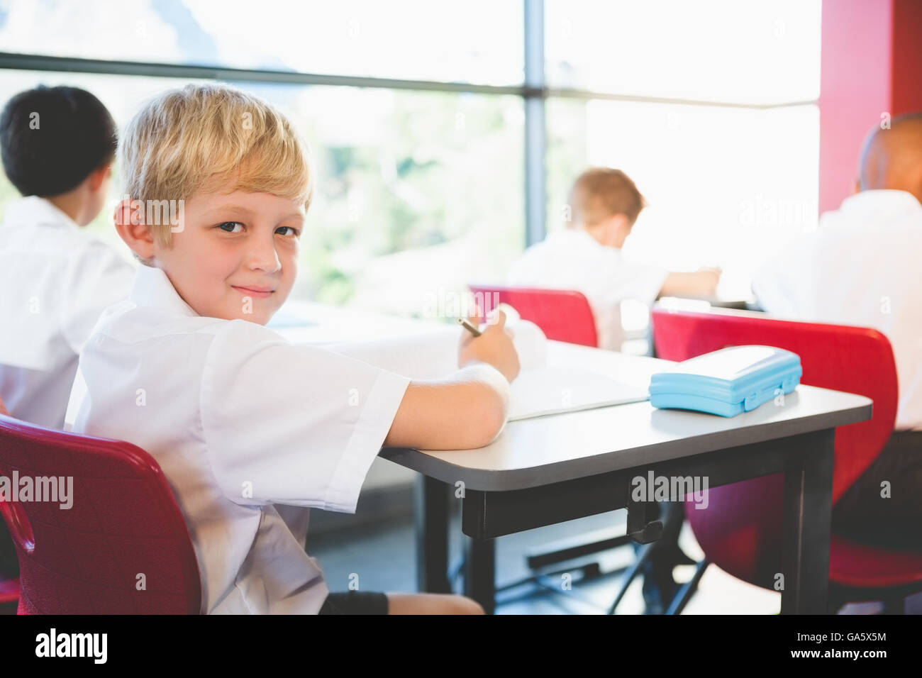 Schoolkids doing homework in classroom Stock Photo - Alamy