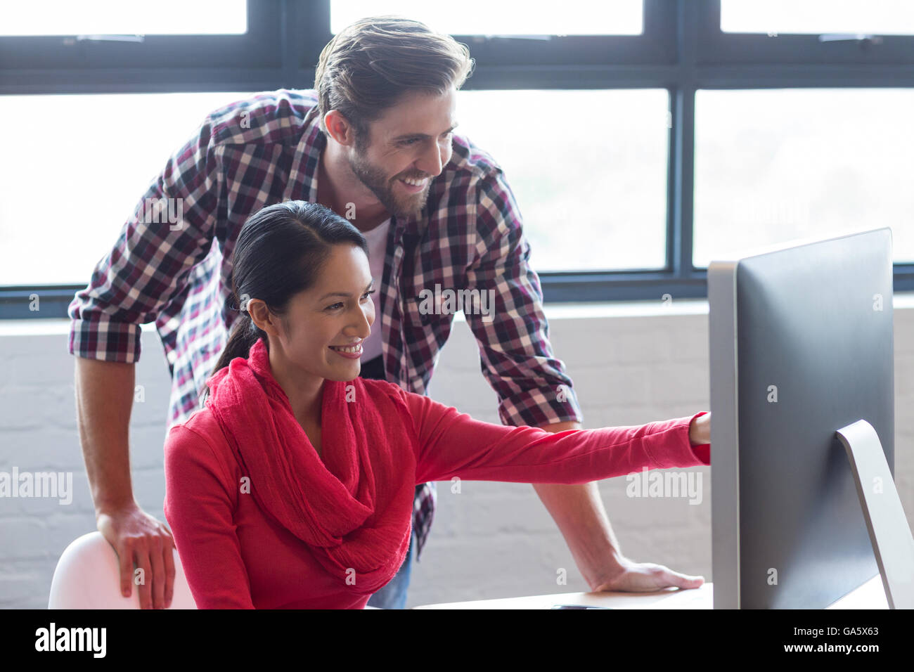 Happy colleagues working in office Stock Photo - Alamy