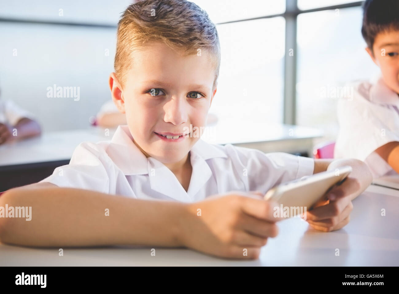Schoolkid using mobile phone in classroom Stock Photo - Alamy