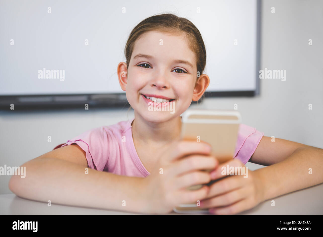 Girl using mobile phone in classroom hi-res stock photography and ...