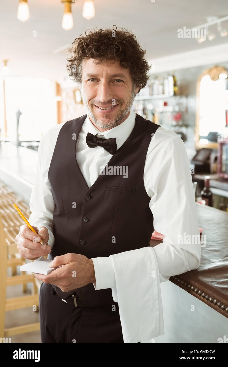 Portrait of waiter holding notepad and pen Stock Photo - Alamy
