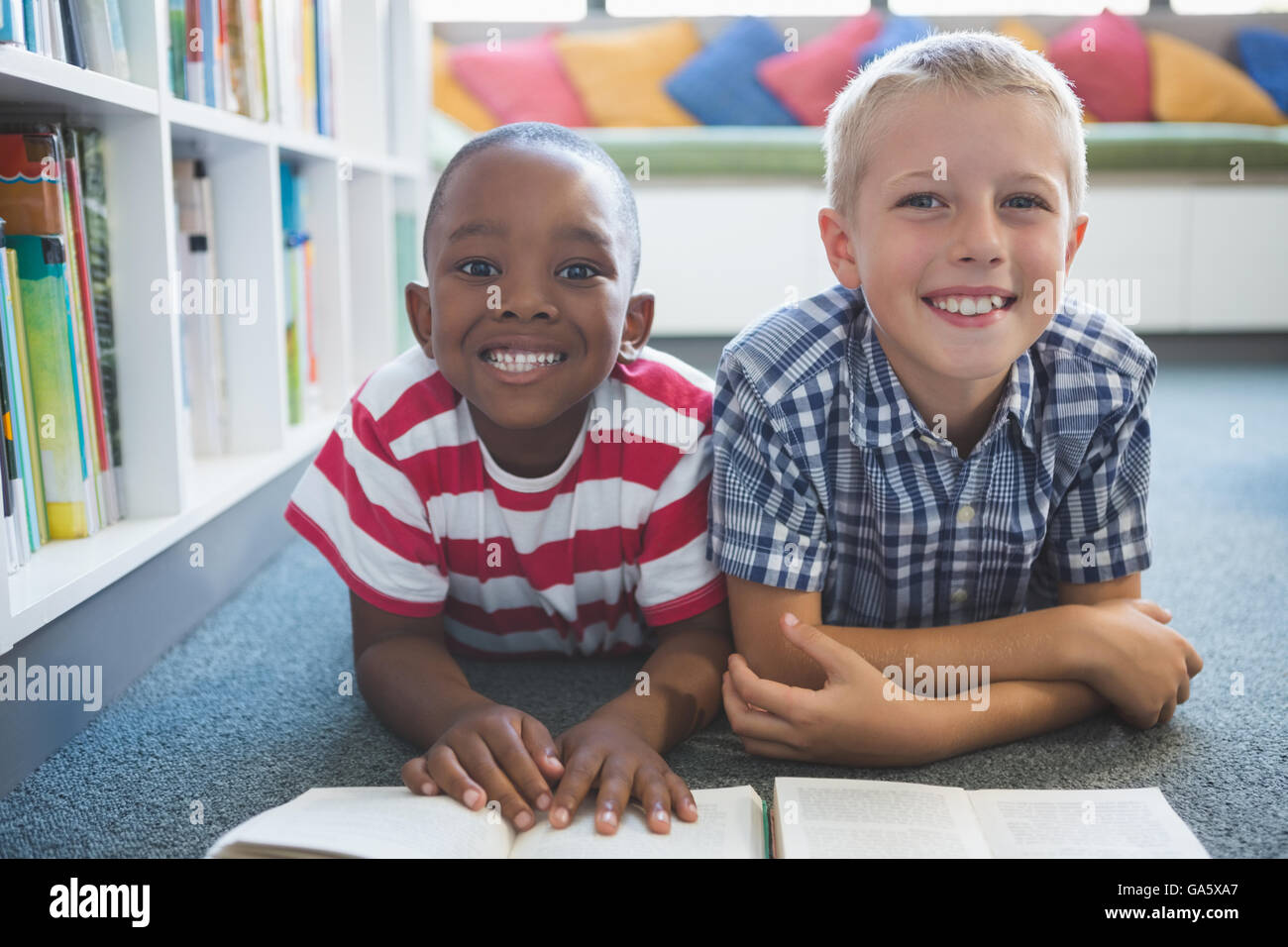 Portrait of school kids reading book in library Stock Photo - Alamy