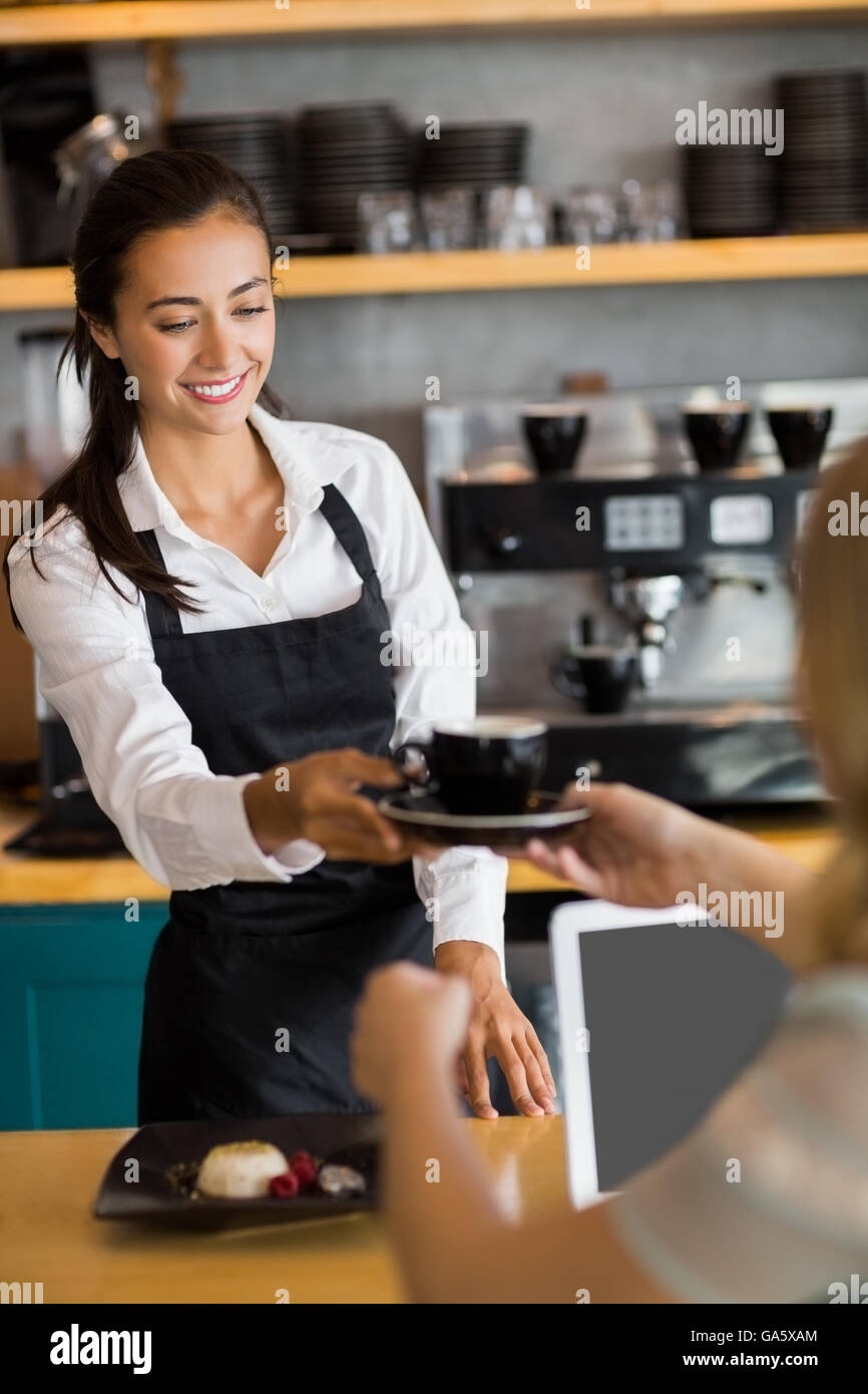 Waitress offering a cup of coffee Stock Photo - Alamy