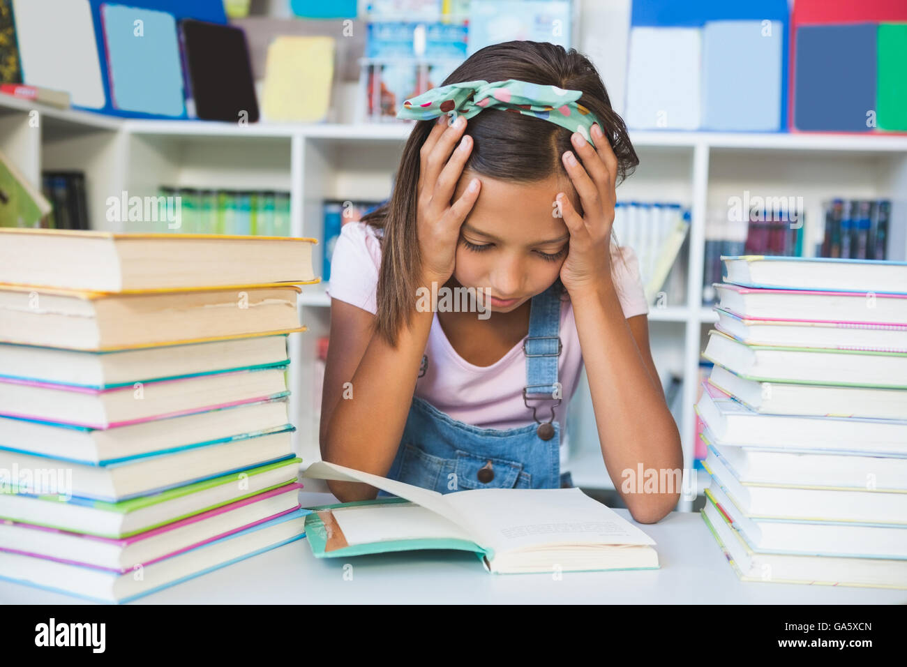 School girl reading a book in library Stock Photo - Alamy