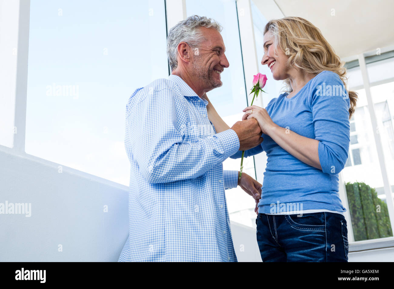 Mature man giving rose to woman Stock Photo - Alamy