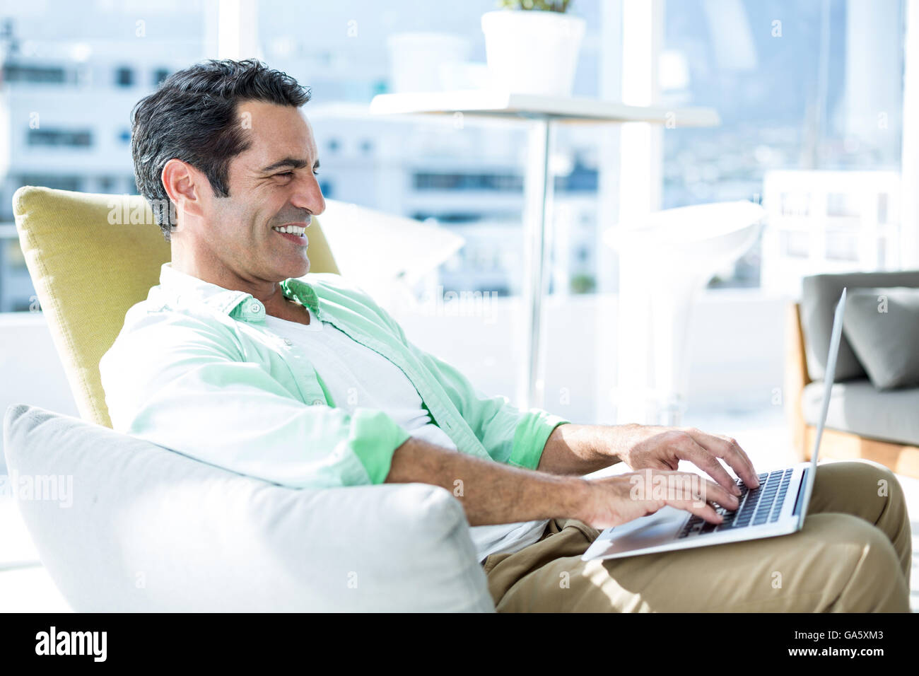 Man smiling while using laptop Stock Photo - Alamy