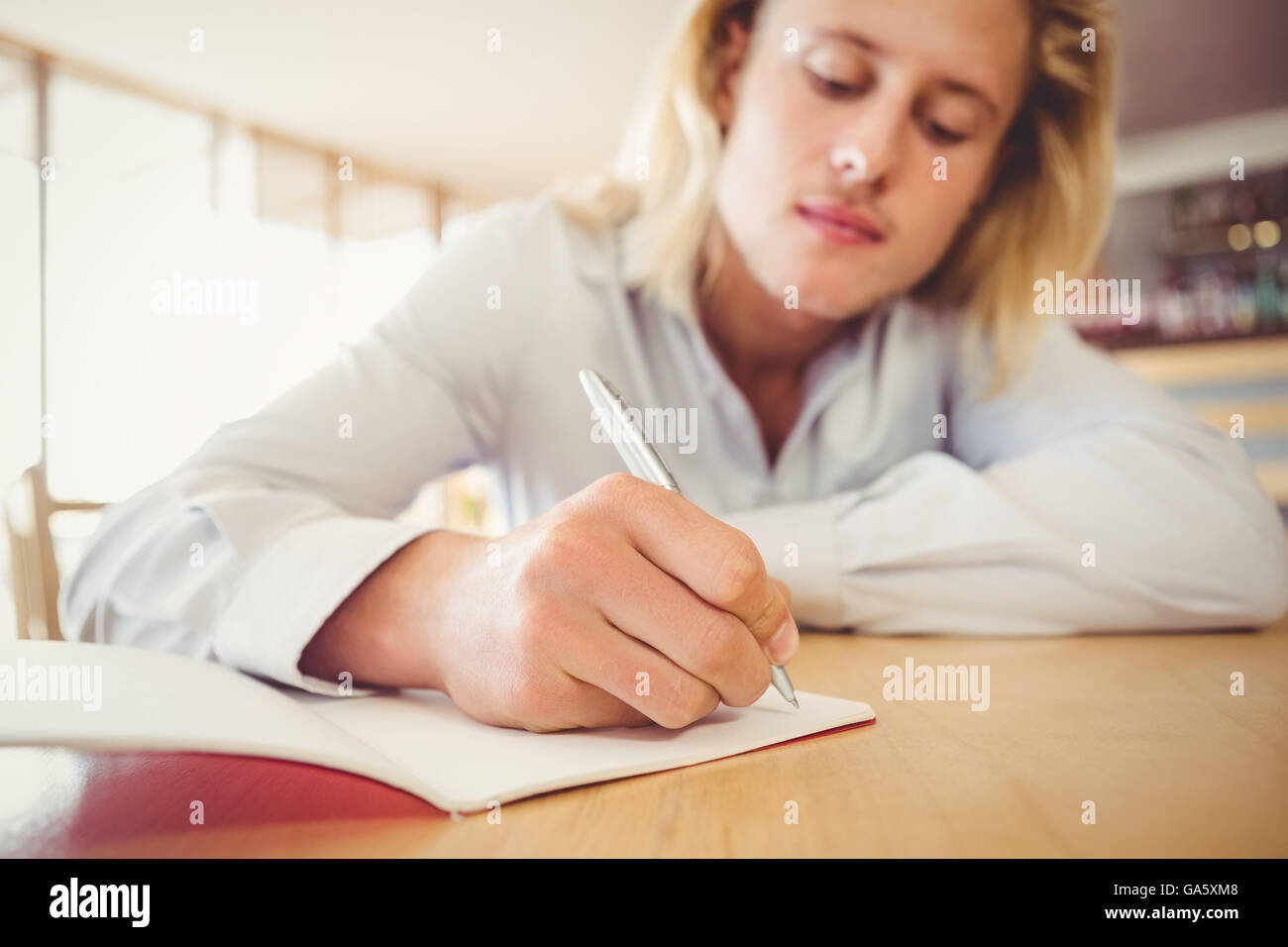 Man writing on a book Stock Photo - Alamy