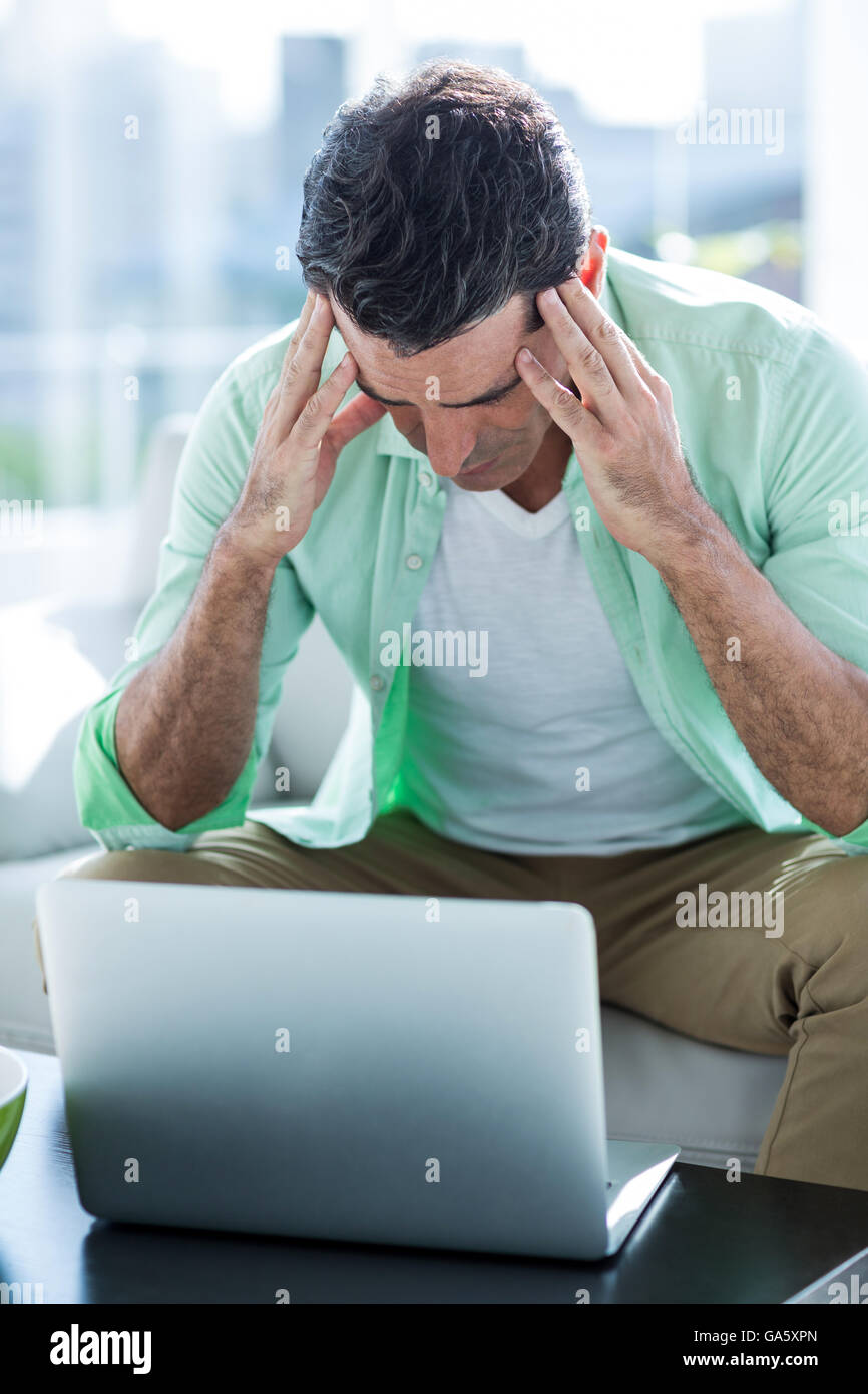 Stressed man with laptop at home Stock Photo - Alamy