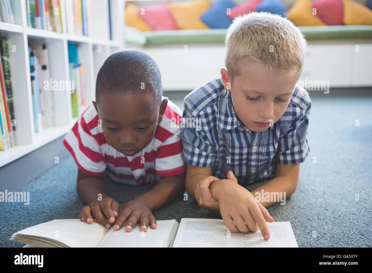 School kids reading book in library Stock Photo - Alamy