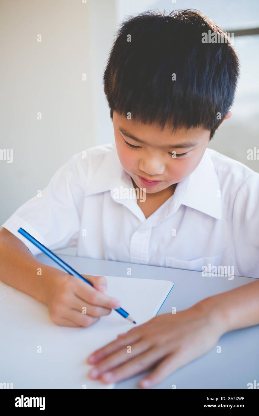 Schoolboy doing homework in classroom Stock Photo - Alamy