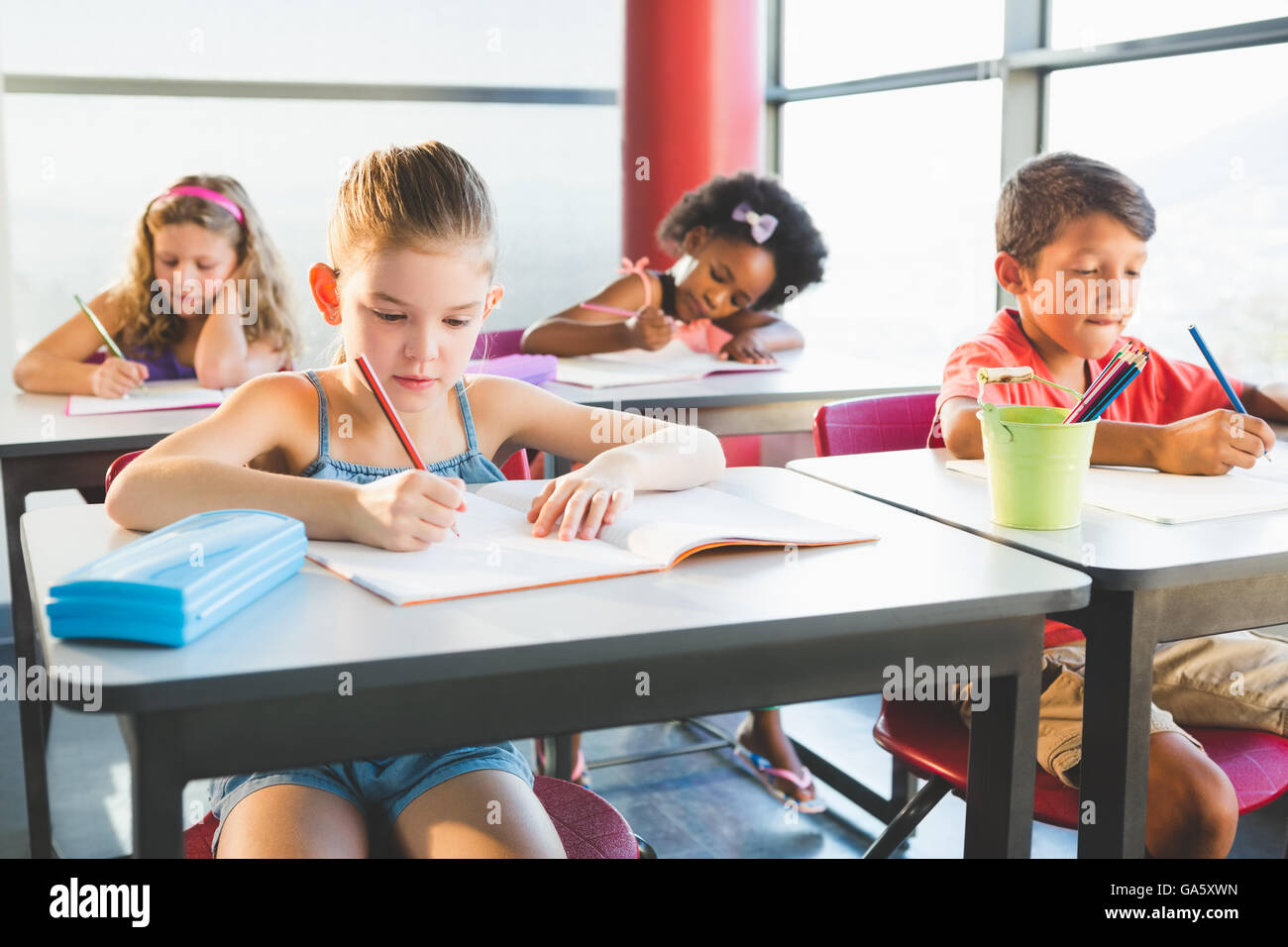 Schoolkids doing homework in classroom Stock Photo - Alamy