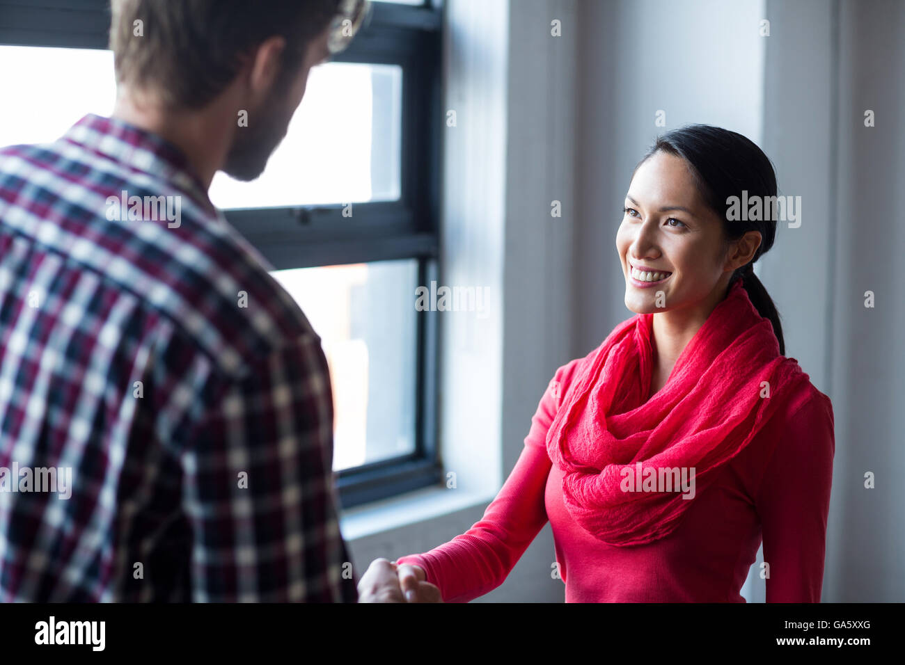 Colleagues shaking hands in office Stock Photo - Alamy