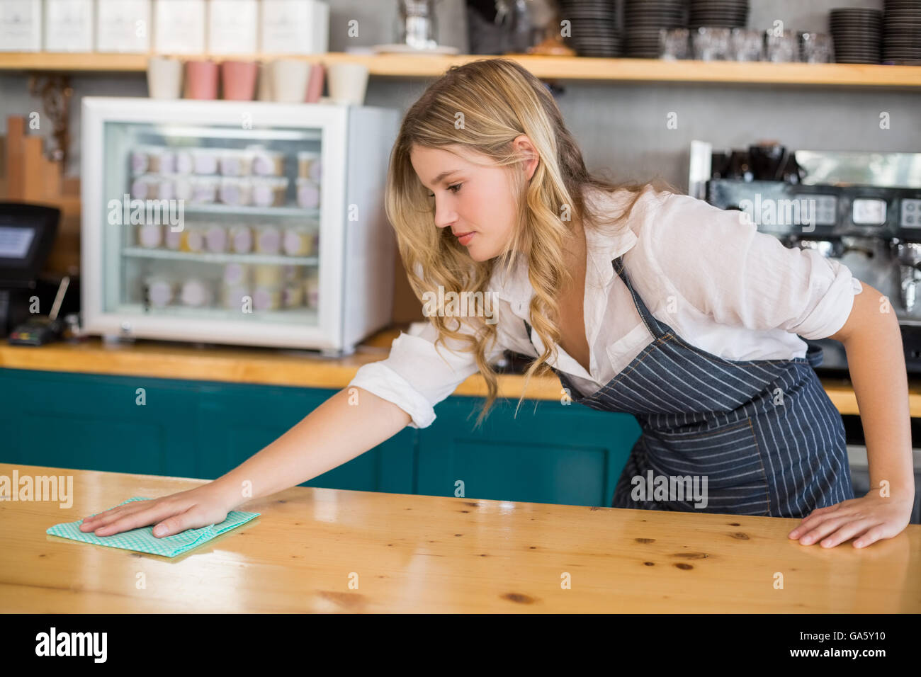Waitress cleaning cafe counter Stock Photo - Alamy