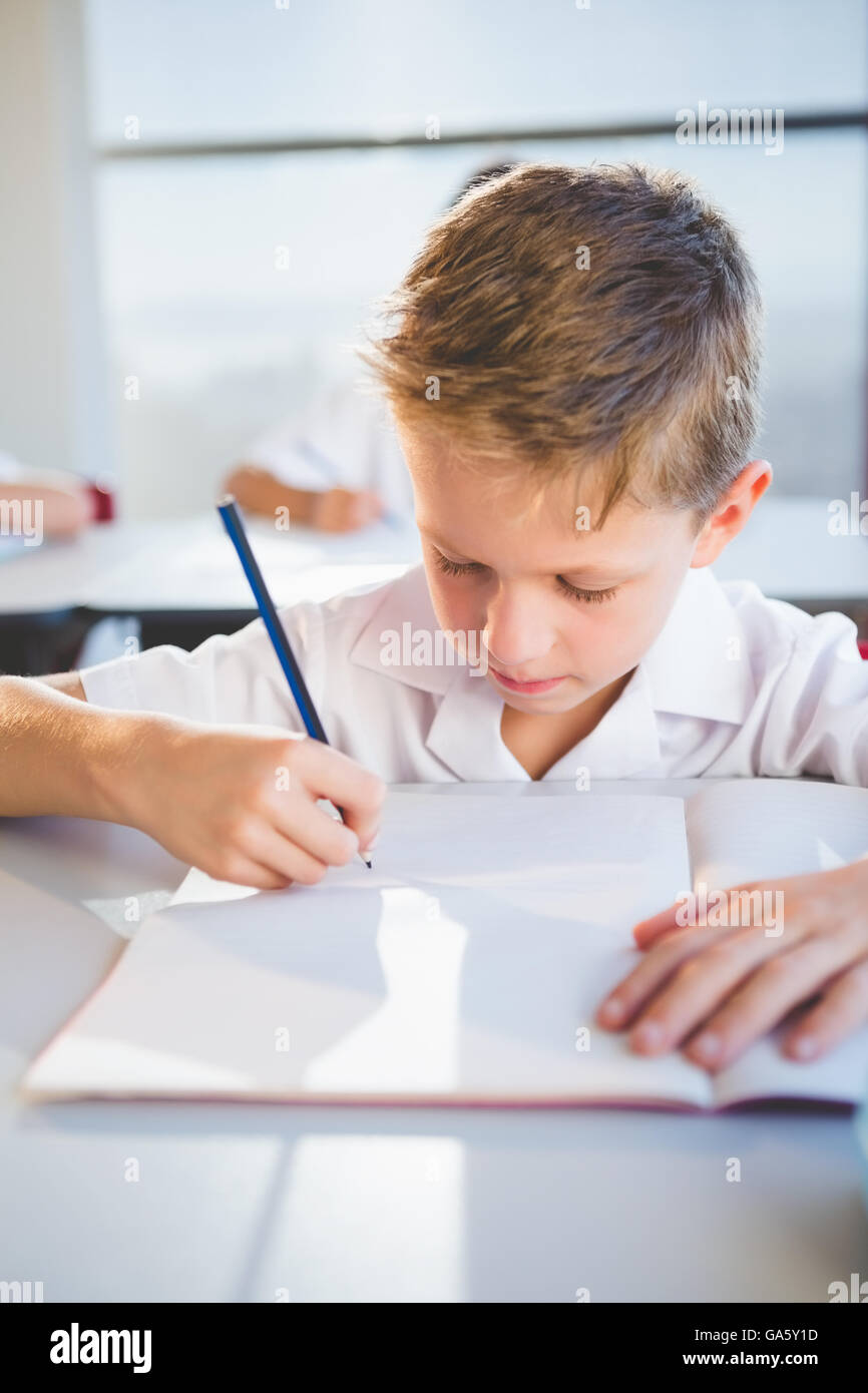 Schoolboy doing homework in classroom Stock Photo - Alamy
