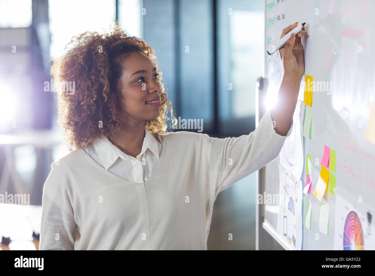 Woman writing on whiteboard Stock Photo - Alamy