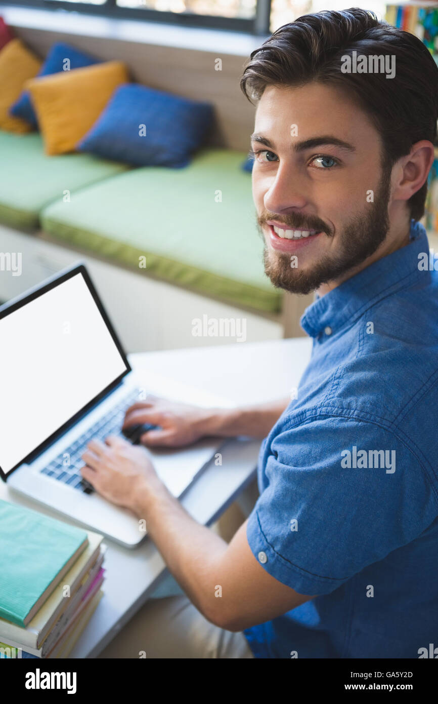 School teacher working on laptop in library Stock Photo - Alamy