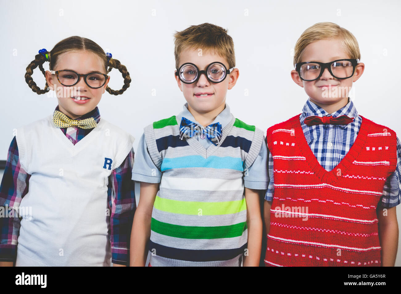 Smiling schoolkids standing in classroom Stock Photo - Alamy