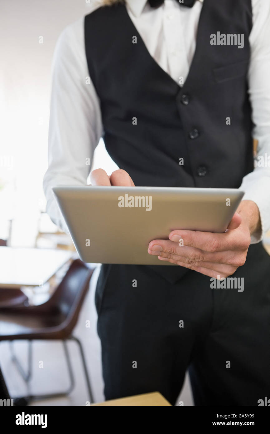 Waiter using digital tablet in restaurant Stock Photo - Alamy