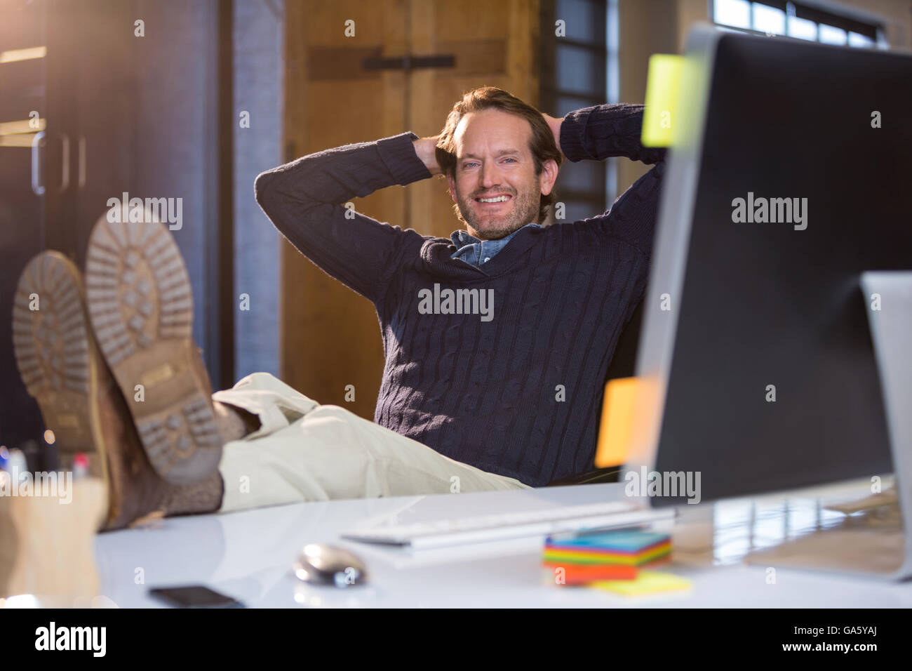Businessman resting at computer desk Stock Photo - Alamy
