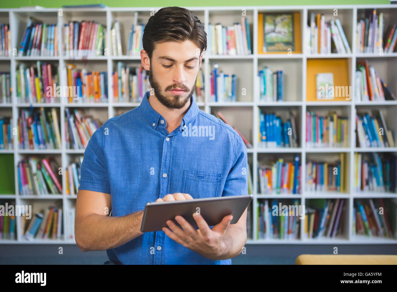School teacher using digital tablet in library Stock Photo - Alamy