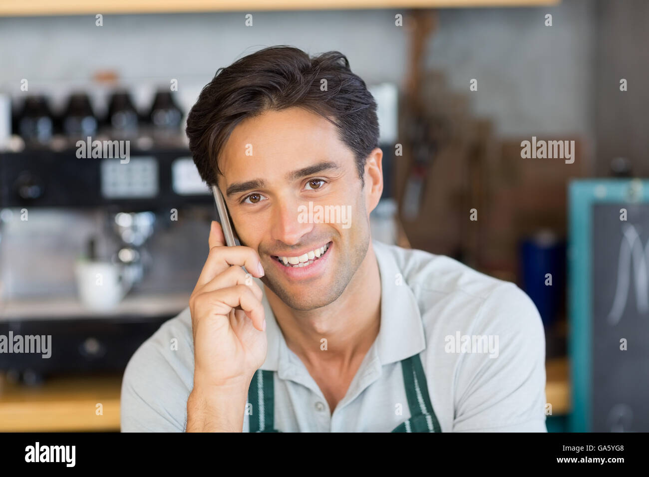 Portrait of waiter talking on mobile phone Stock Photo - Alamy
