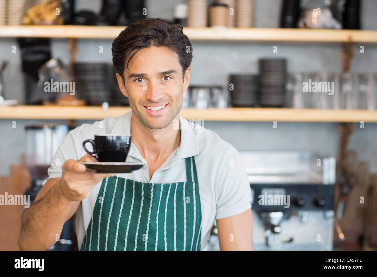 Waiter offering a cup of coffee Stock Photo - Alamy