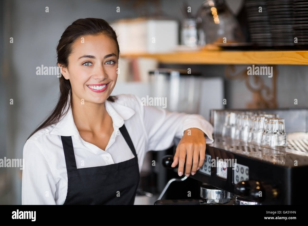 Portrait of smiling waitress making cup of coffee Stock Photo - Alamy