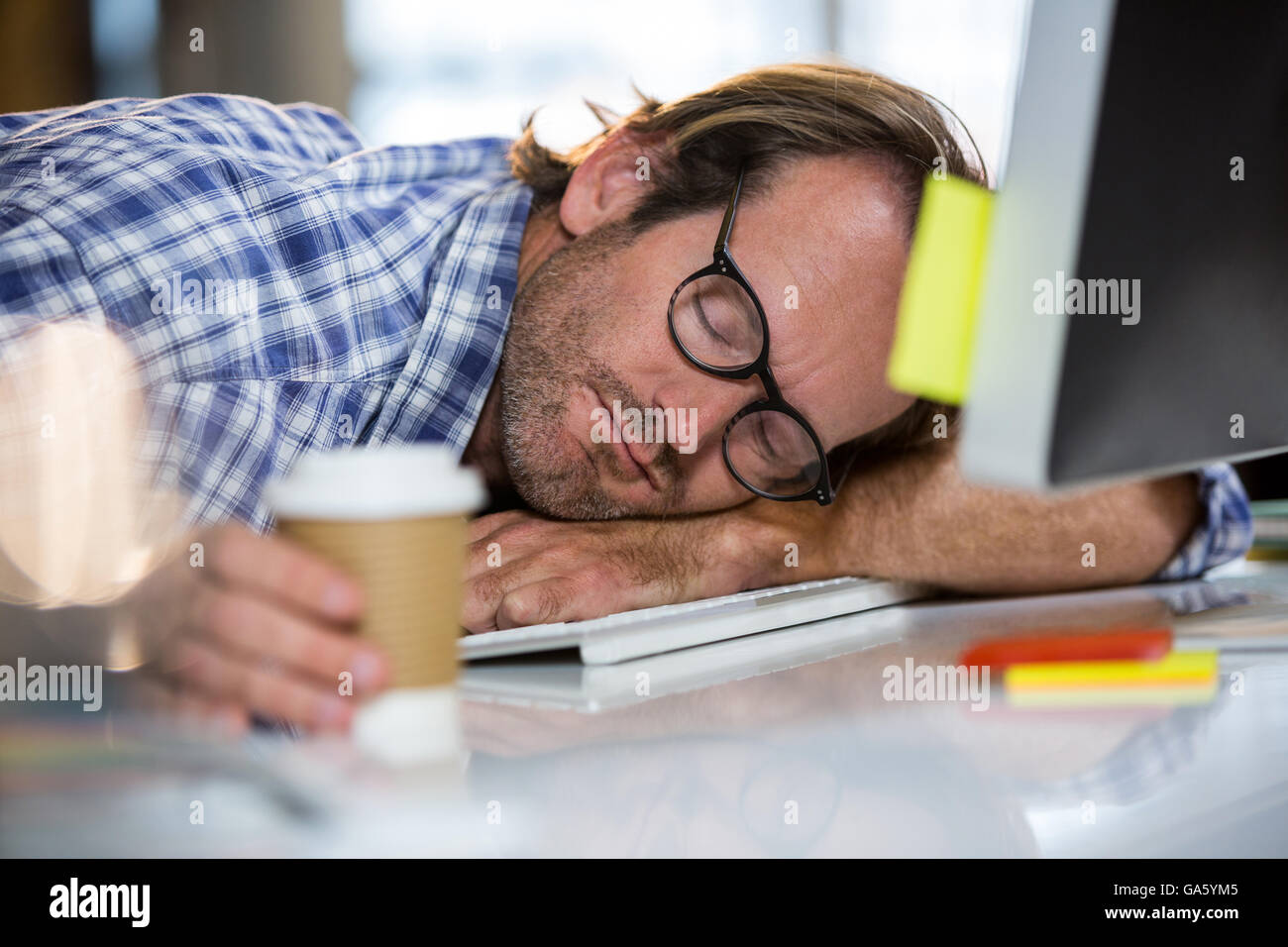 Businessman napping on computer desk Stock Photo - Alamy