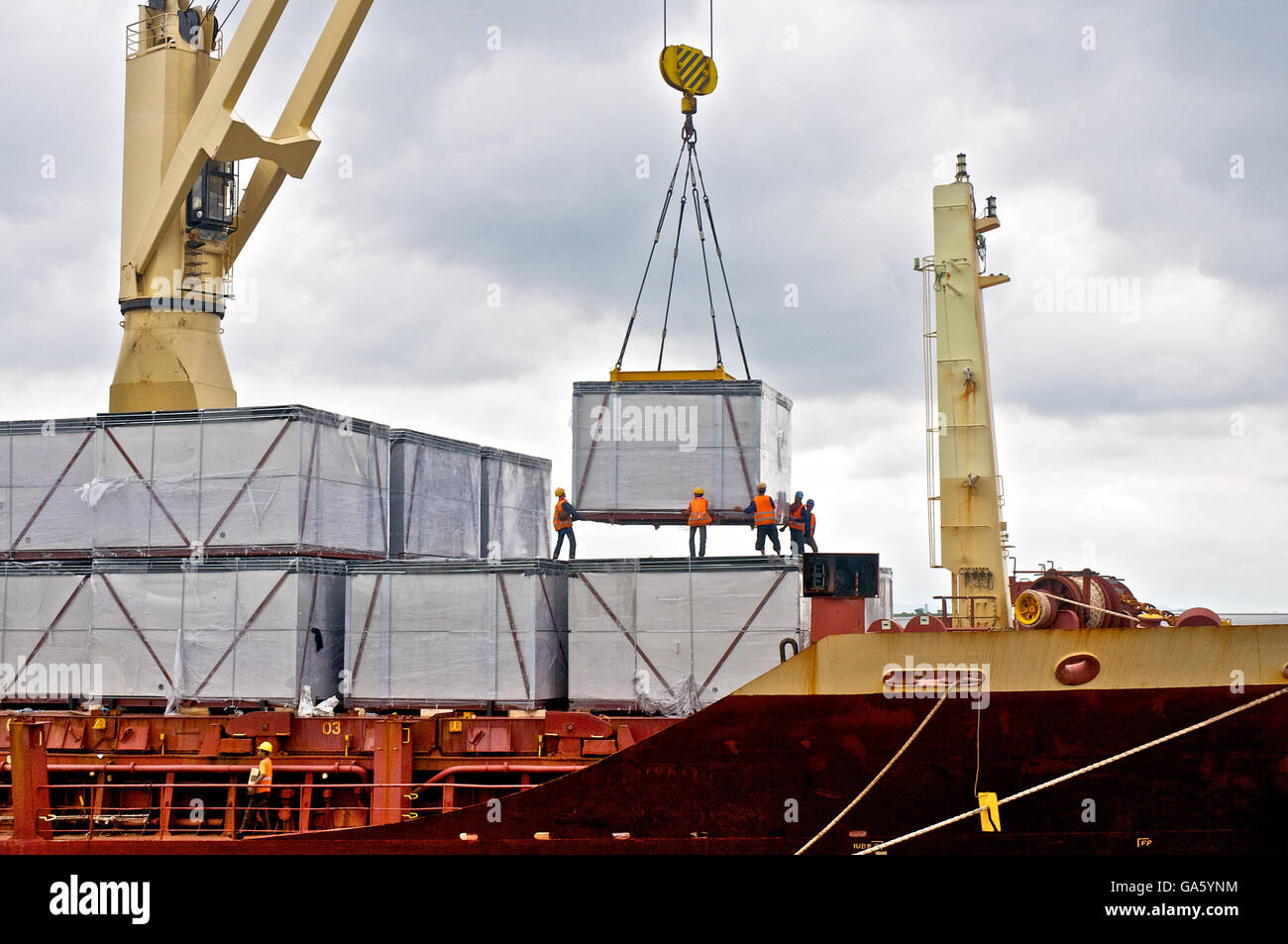 Cargo ship loading cargo into the ship in the harbor Stock Photo - Alamy
