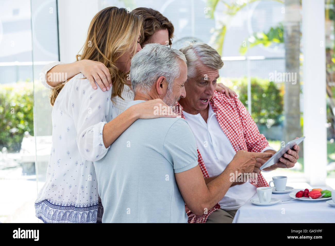 Friends using digital tablet Stock Photo - Alamy