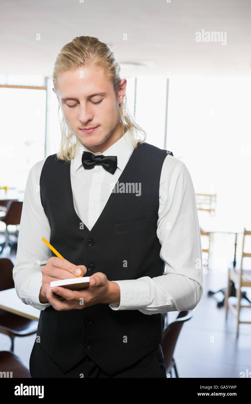 Waiter writing order on notepad Stock Photo - Alamy