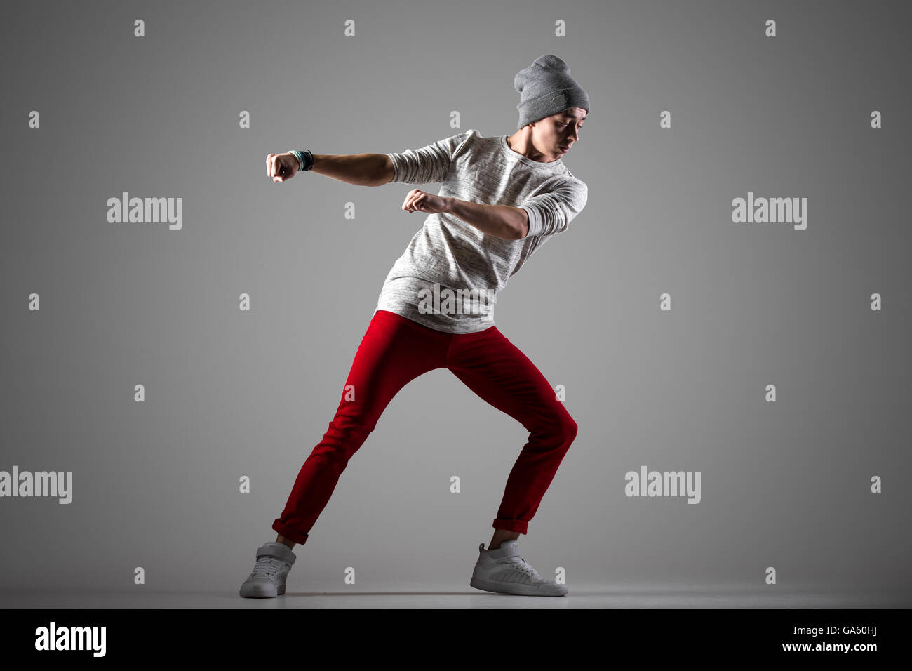 One attractive fit young man in casual red jeans working out, dancing ...