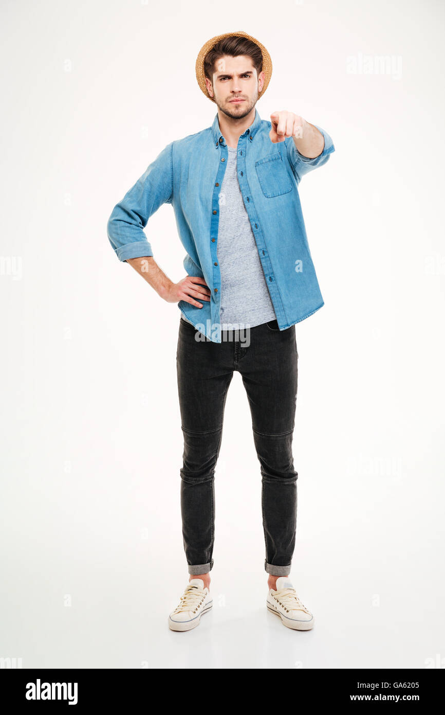 Full length of confident handsome young man standing and pointing on ...