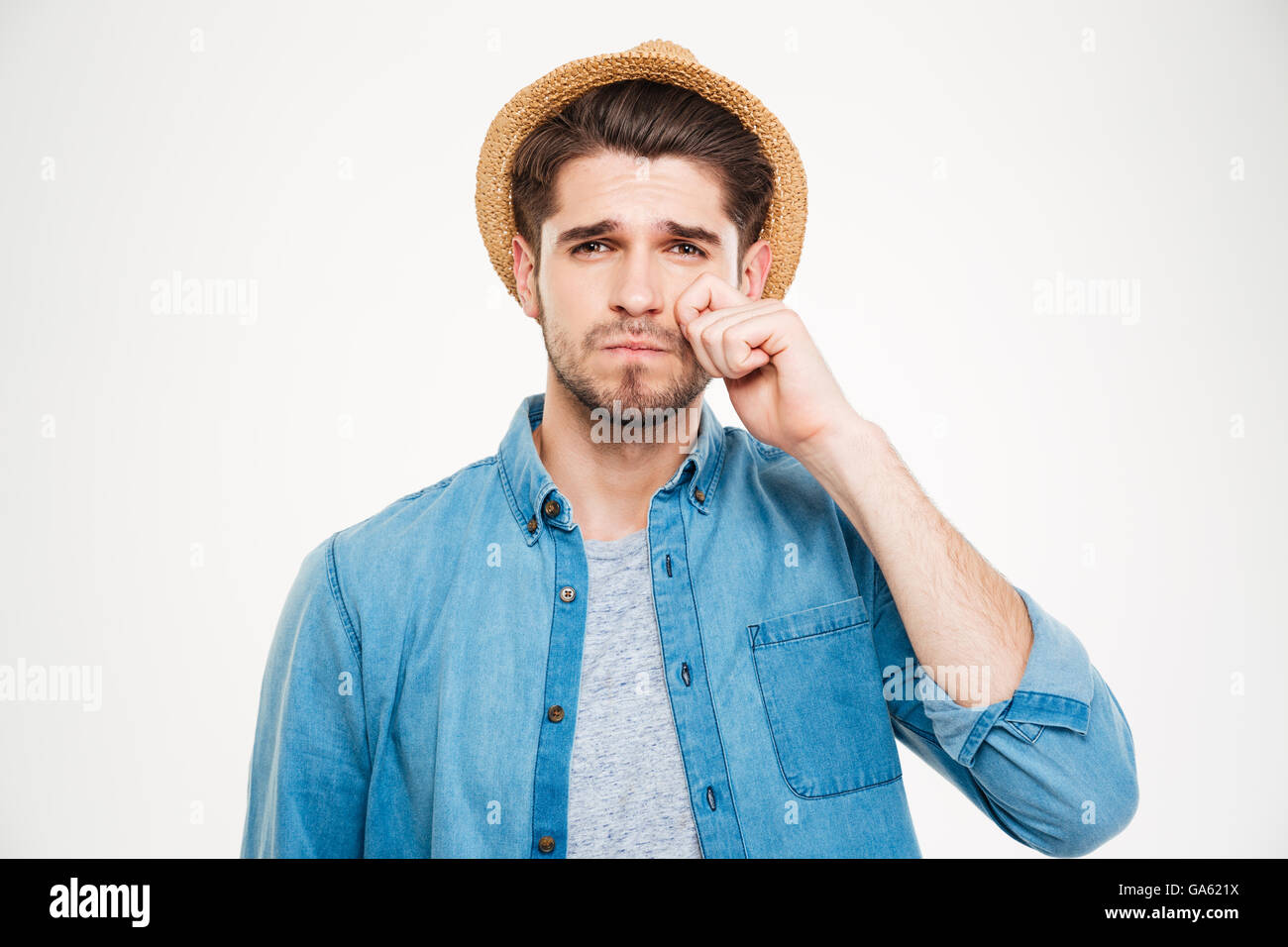 Closeup of sad young man in head standing and crying over white ...