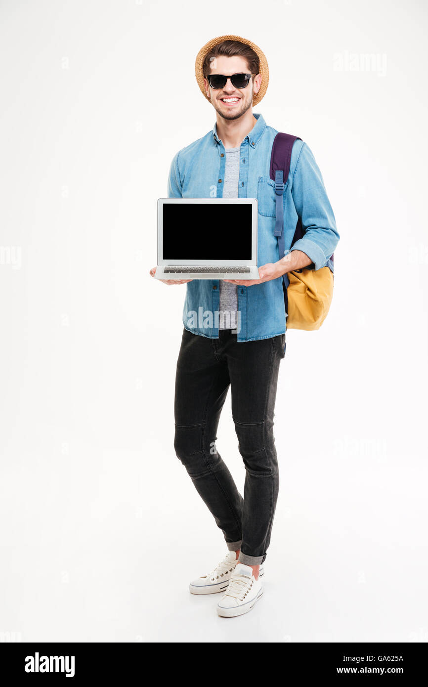 Full length of smiling young man with backpack standing and holding ...