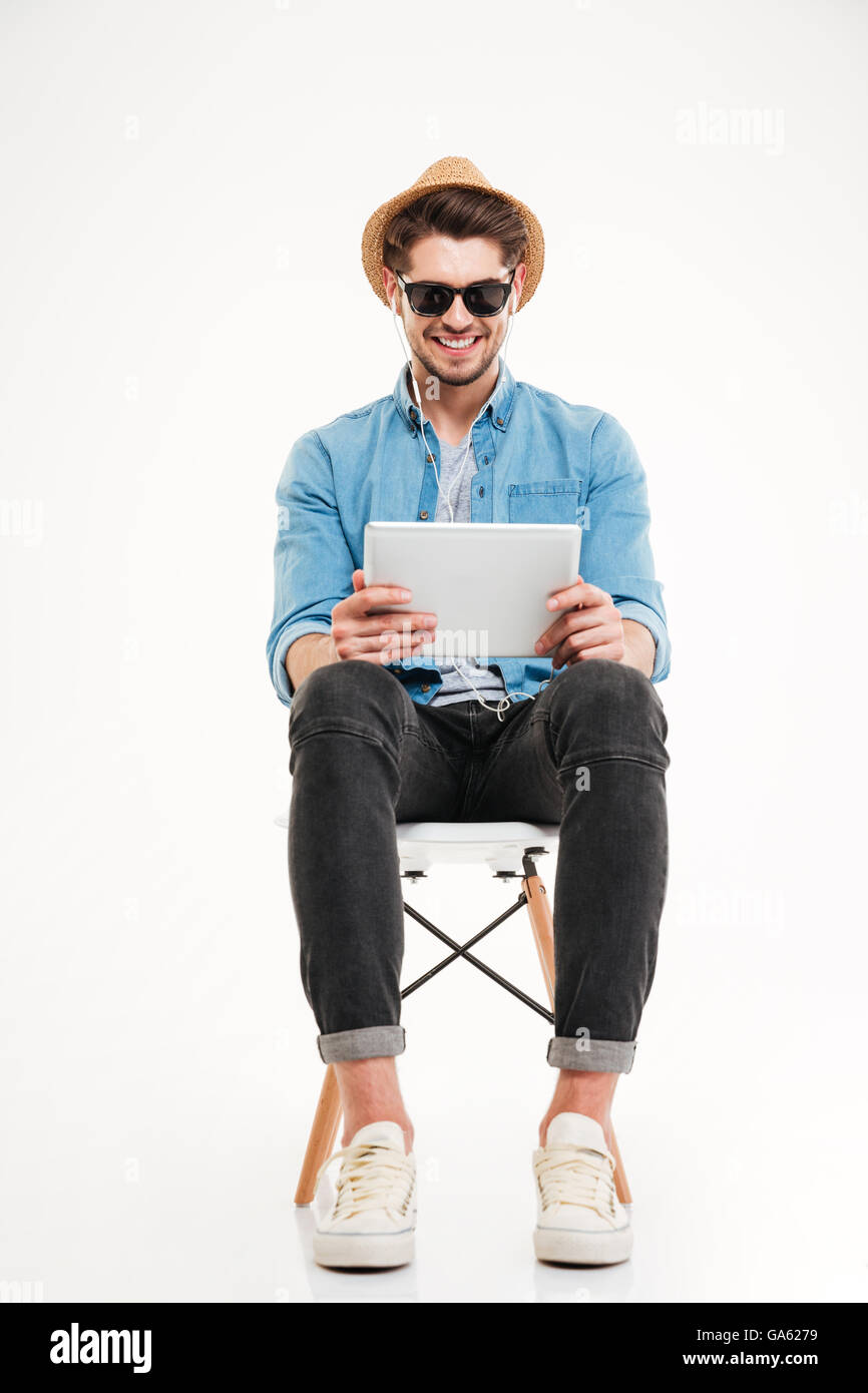 Handsome attractive smiling happy young male using tablet and sitting ...
