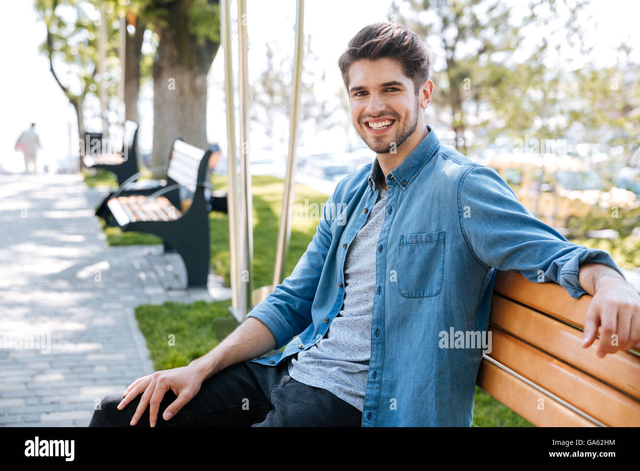 Young man on park bench hi-res stock photography and images - Alamy