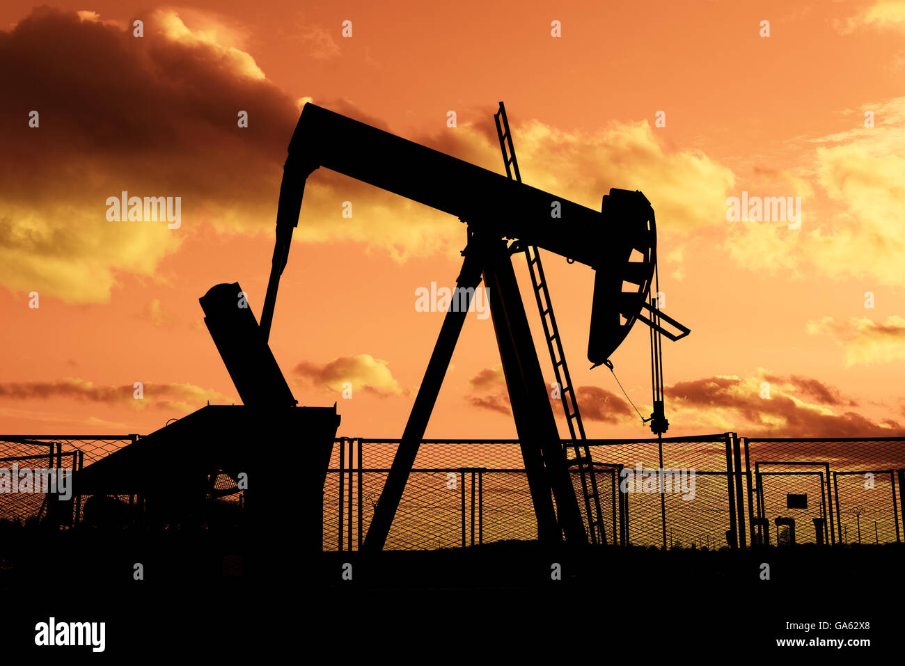 oil rig pumping on cloudy sky background at dusk Stock Photo - Alamy