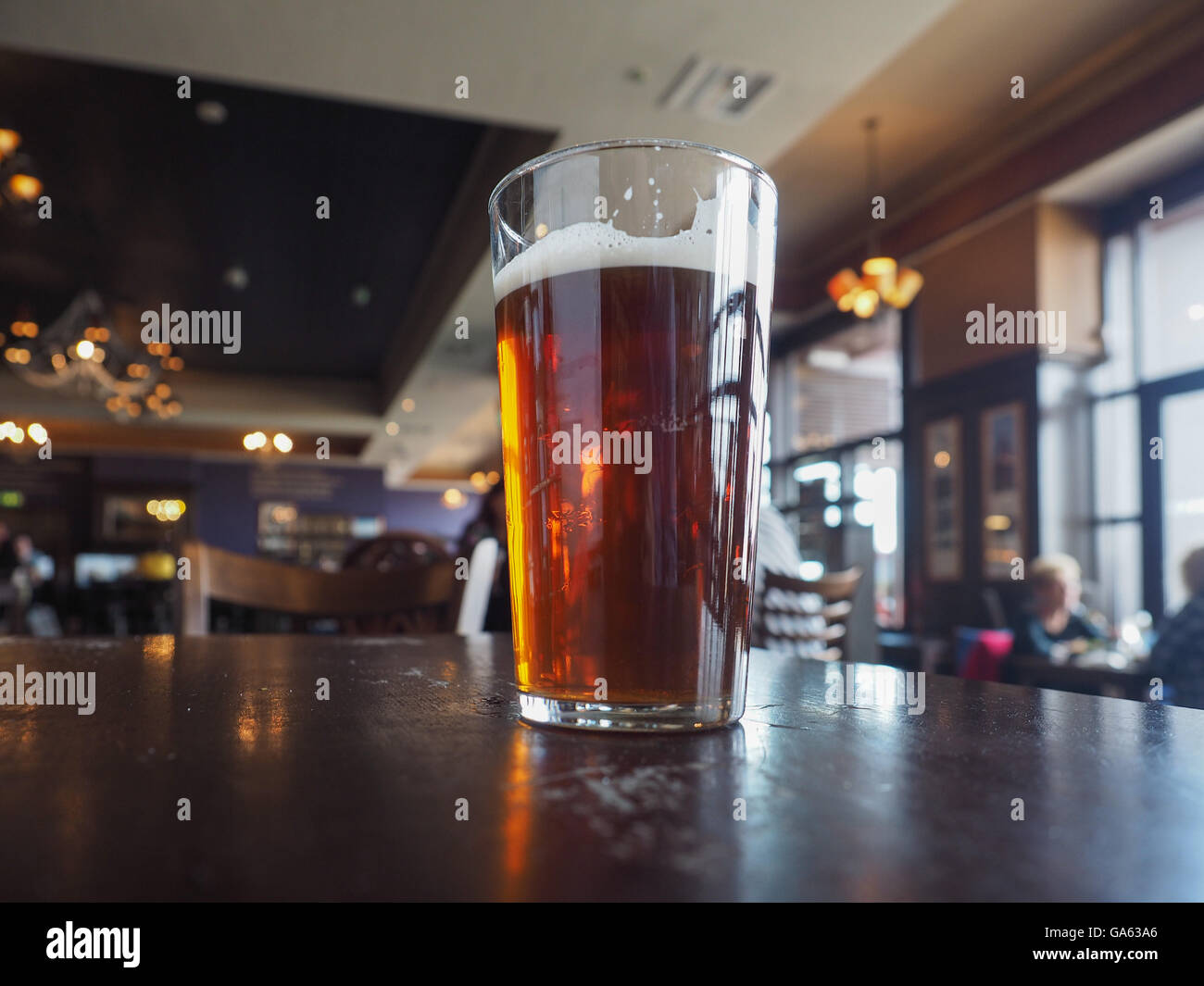 A pint of British ale beer in a pub, selective focus on glass with ...