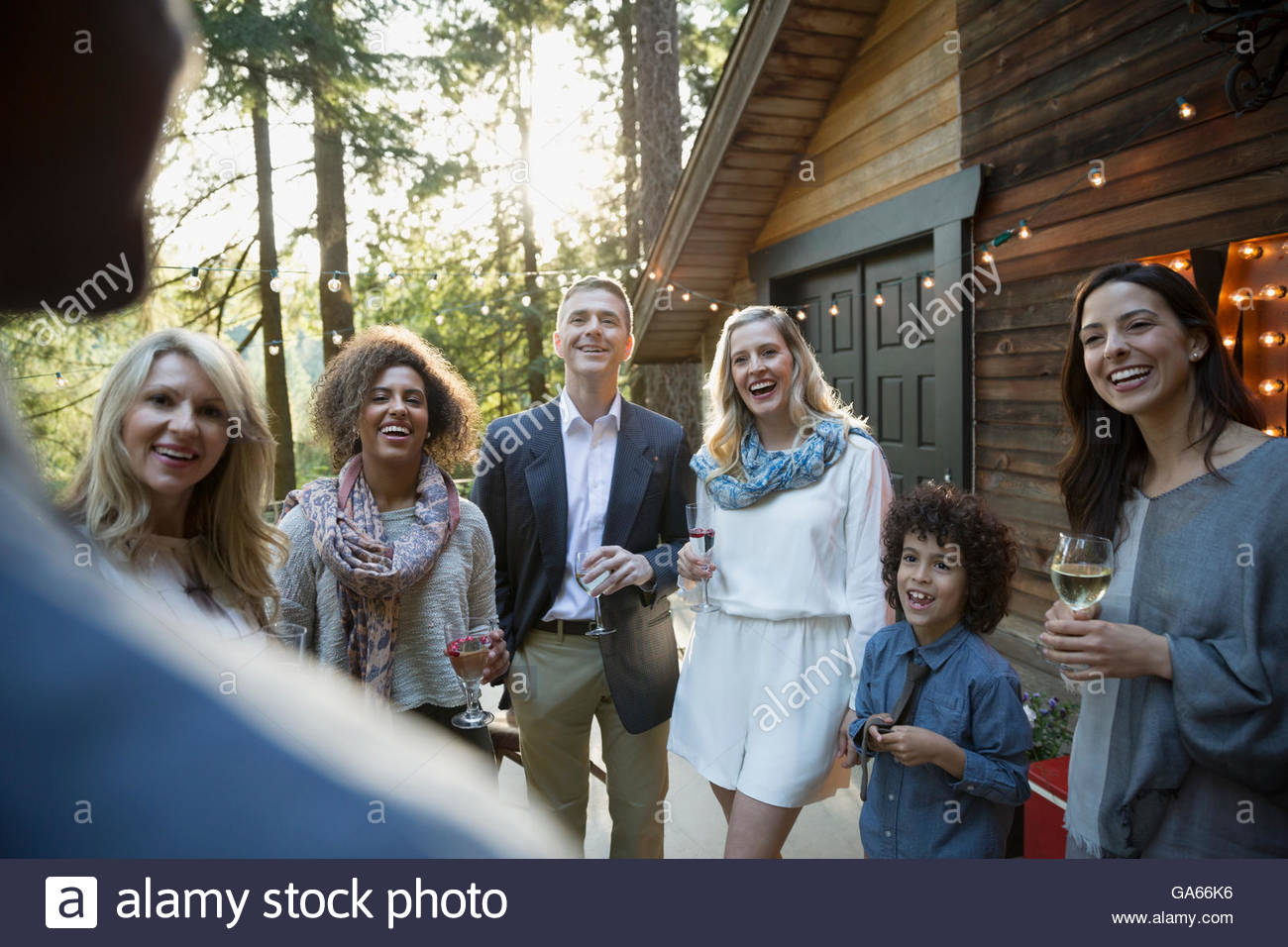 Smiling friends drinking at cabin balcony party Stock Photo - Alamy