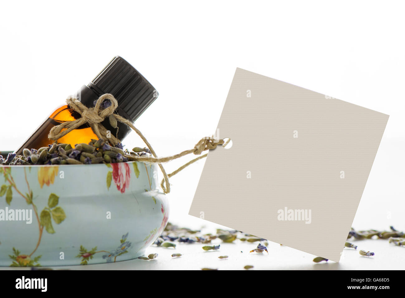 Essential oil, empty tag inside a vintage tin, and lavender flowers on ...