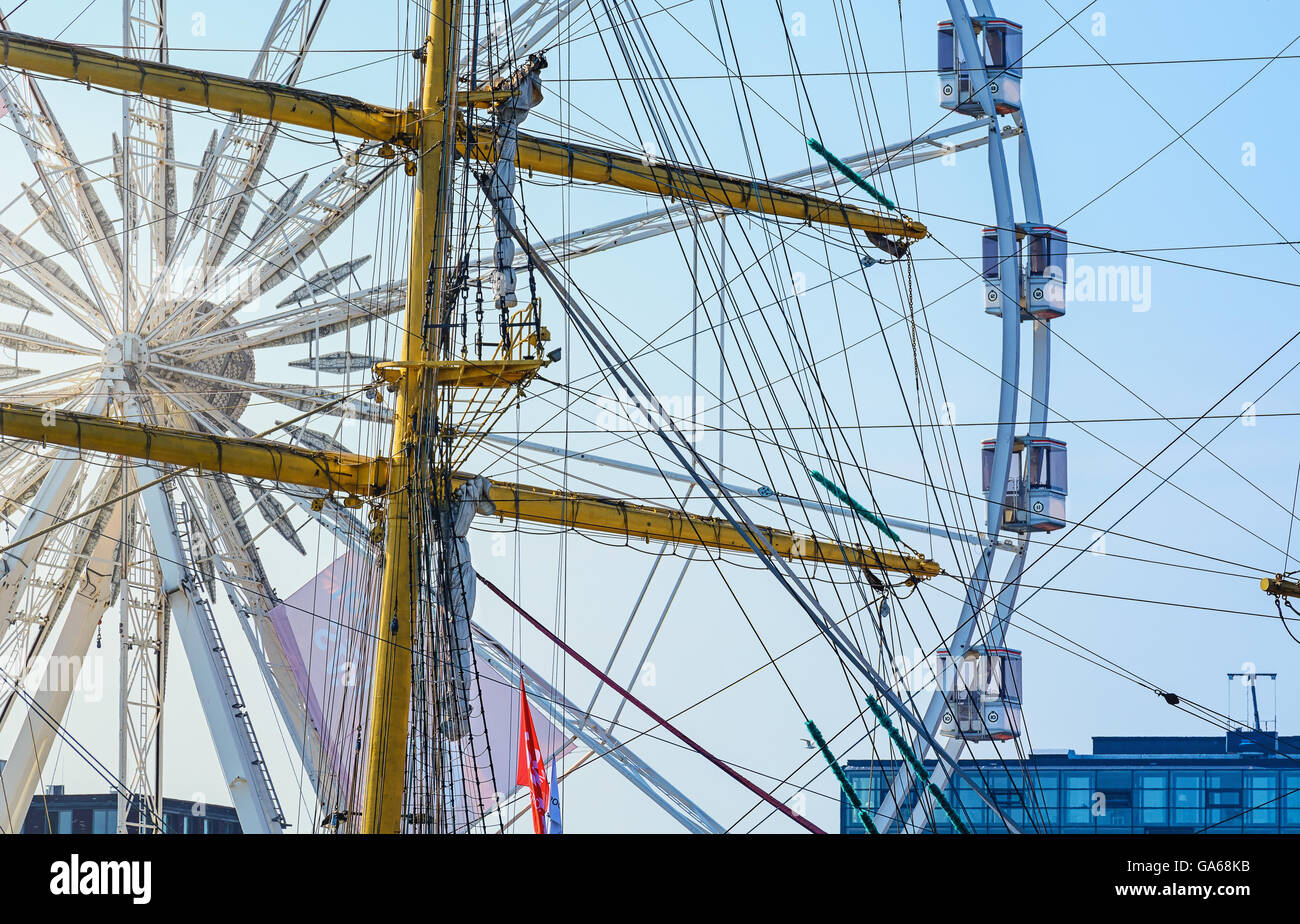 The mast with rigging of a sailing ship with a Ferris wheel on the ...