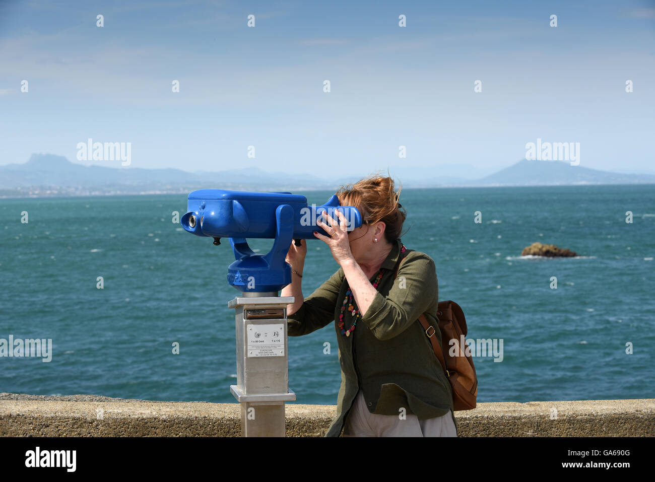 Woman tourist using beach seafront seaside telescope Biarritz France ...