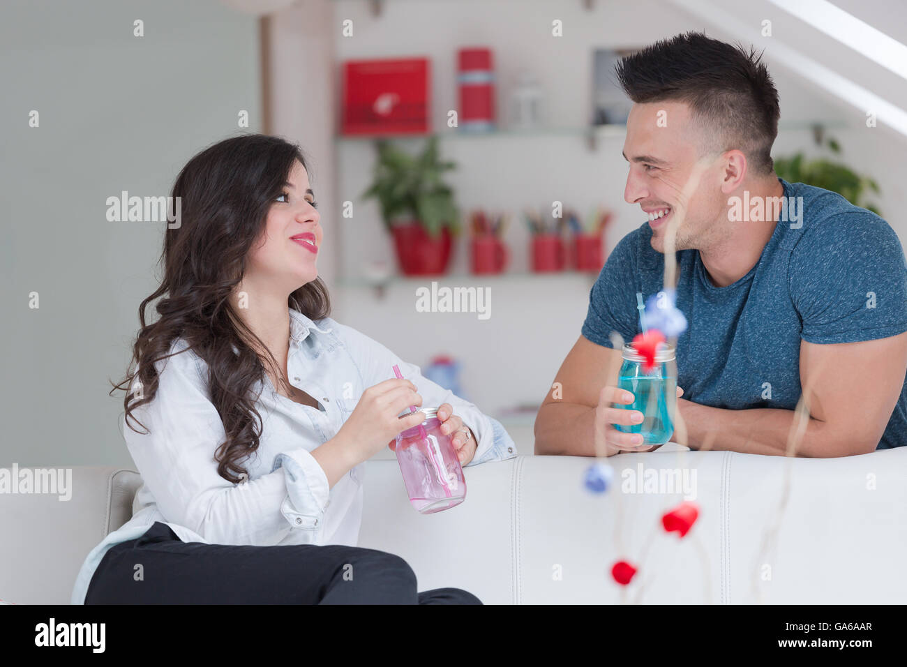 Front view of a couple or marriage talking sitting on a couch and ...