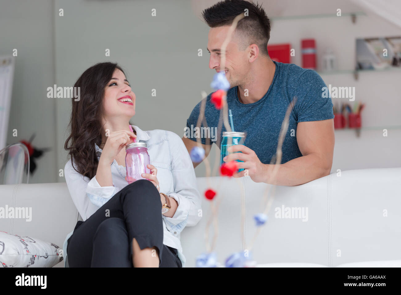 Front view of a couple or marriage talking sitting on a couch and ...